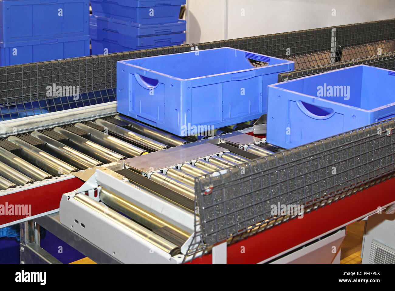 Plastic Crates at Conveyor Belt Rollers in Factory Stock Photo - Alamy