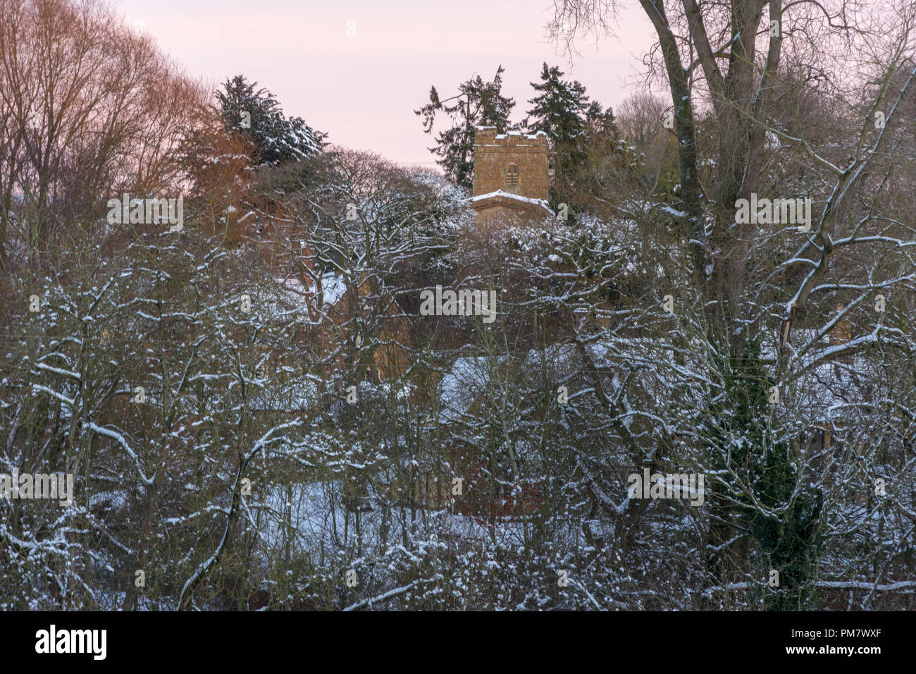 Stone English village church pictured in snow in winter with clear sky ...