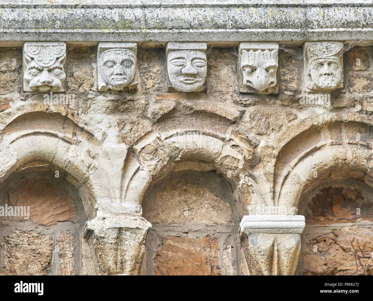 Arches and grotesque stone carvings on an external wall of the twelfth ...