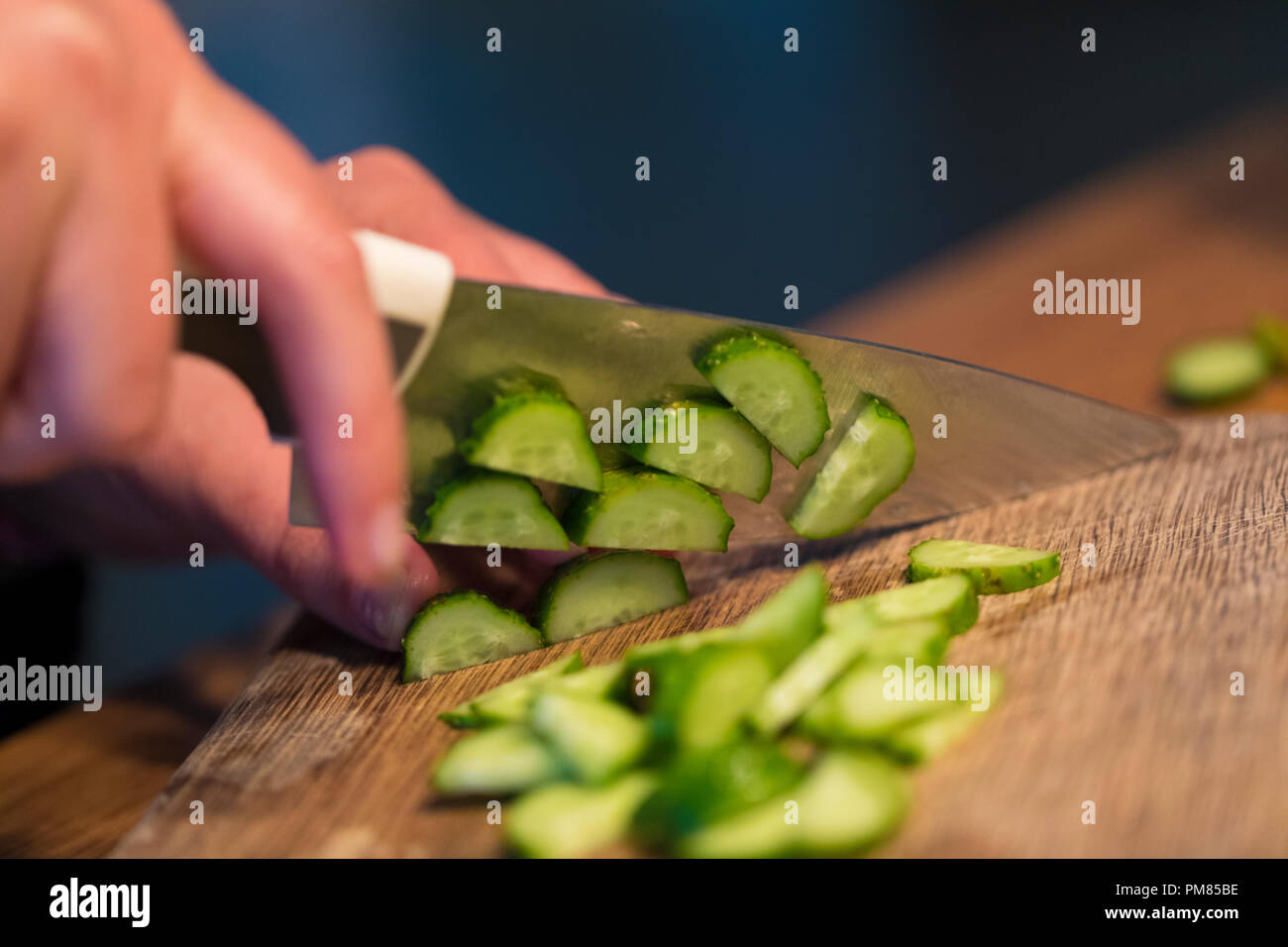 A person cutting up a cucumber Stock Photo - Alamy