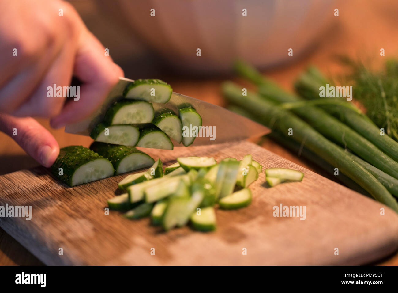 A person cutting up a cucumber Stock Photo - Alamy
