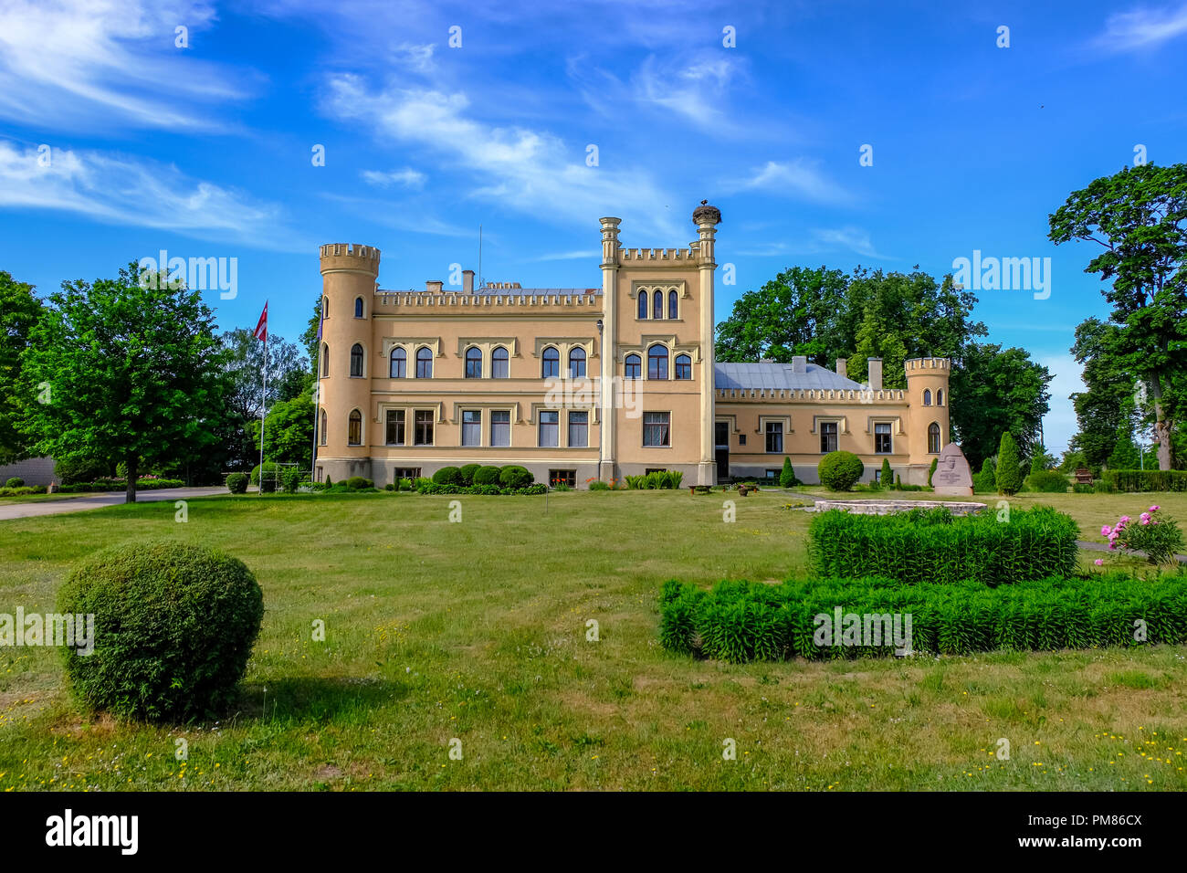 vintage yellow brick manor in countryside with flowers in front of it ...