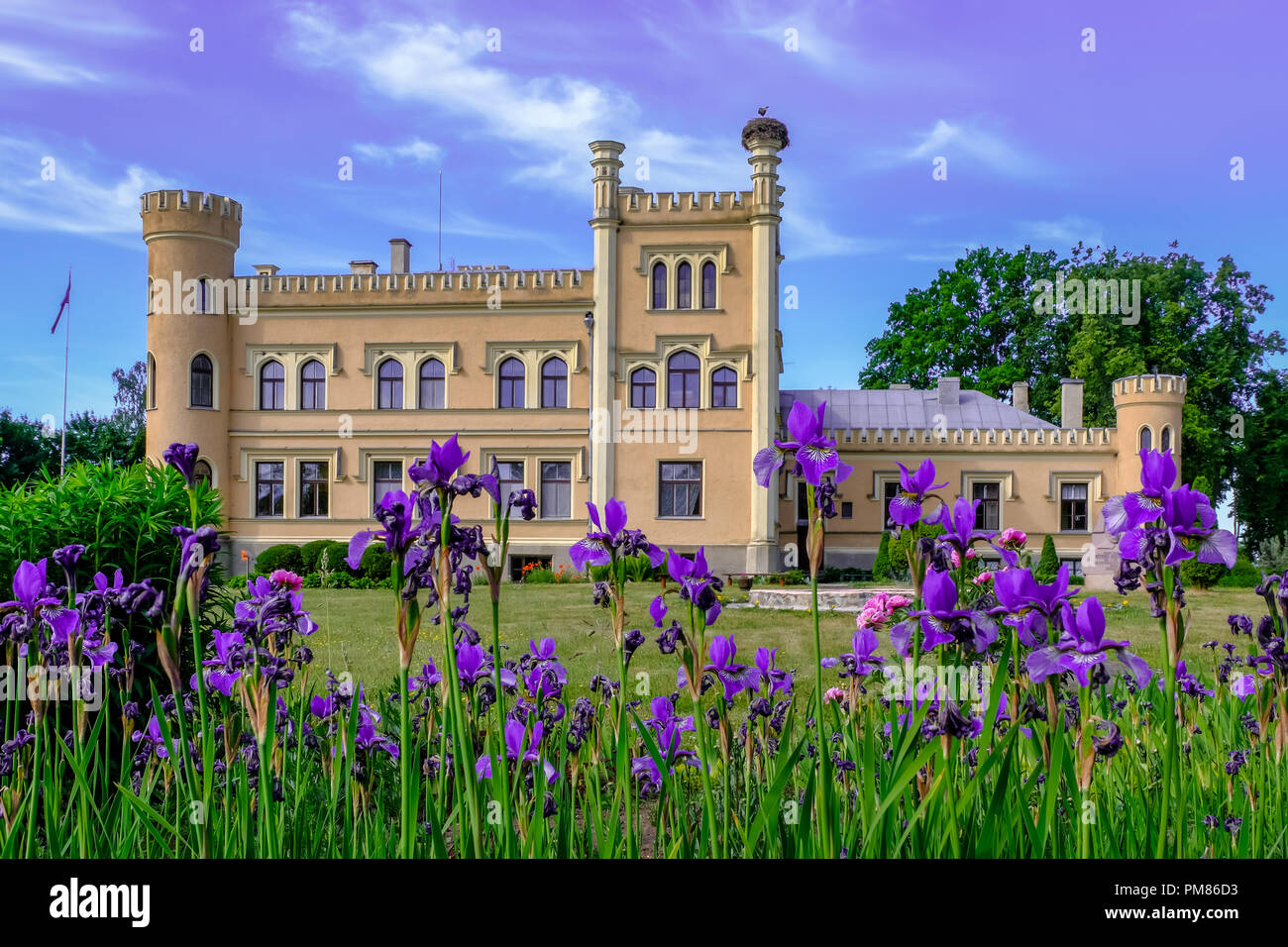 vintage yellow brick manor in countryside with flowers in front of it ...