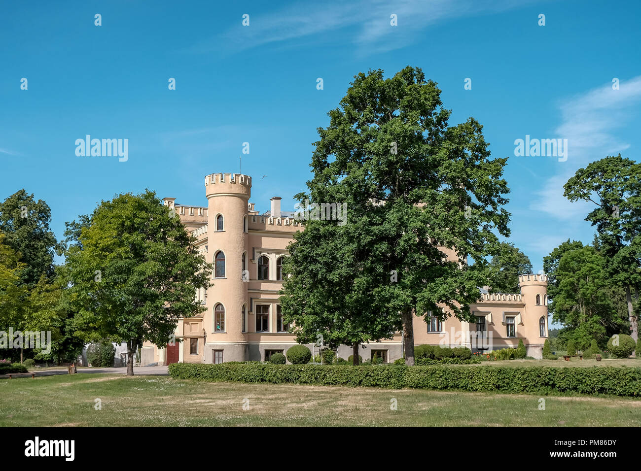 vintage yellow brick manor in countryside with flowers in front of it ...