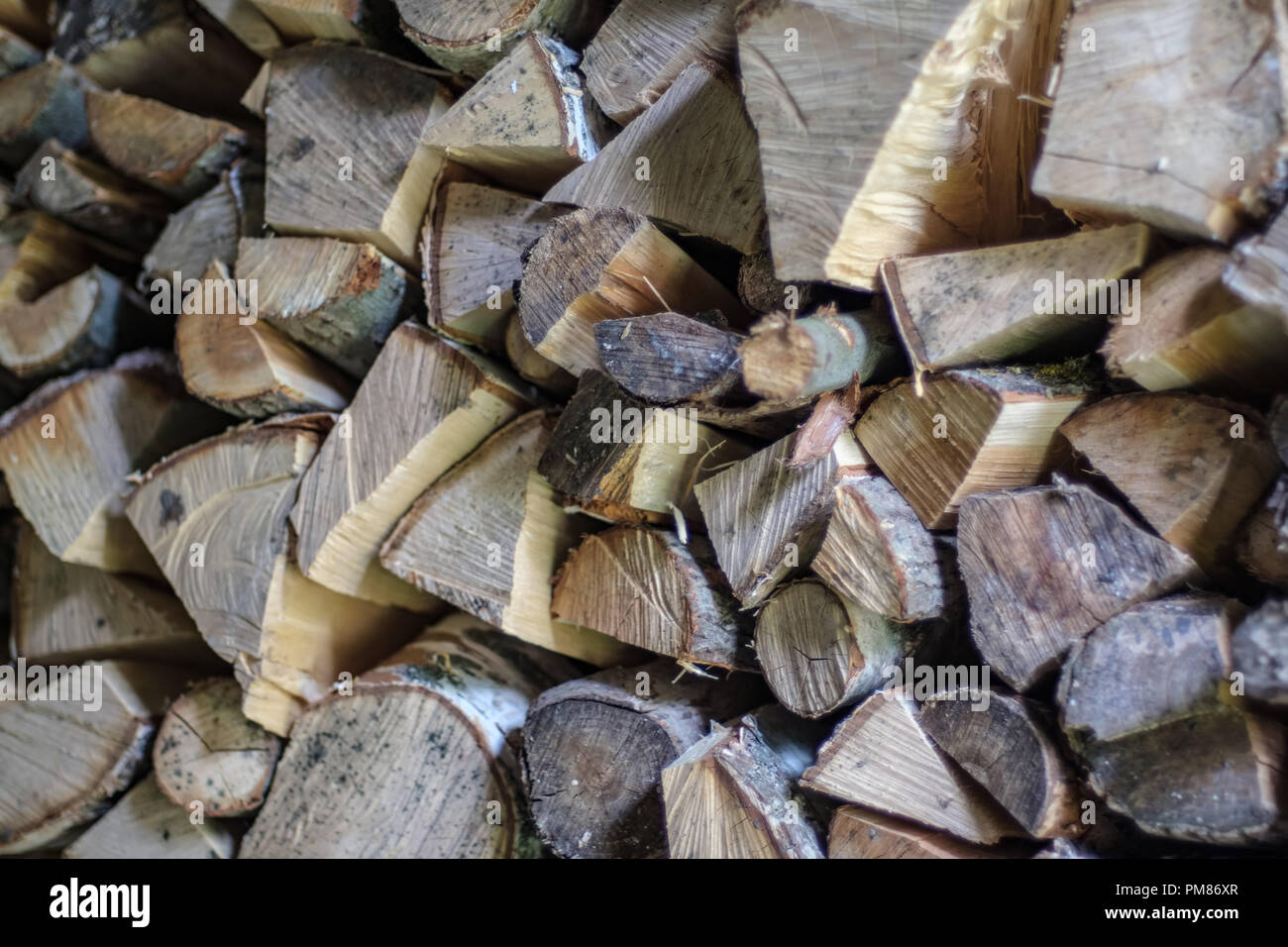 large pile of fire wood in countryside inside barn Stock Photo - Alamy