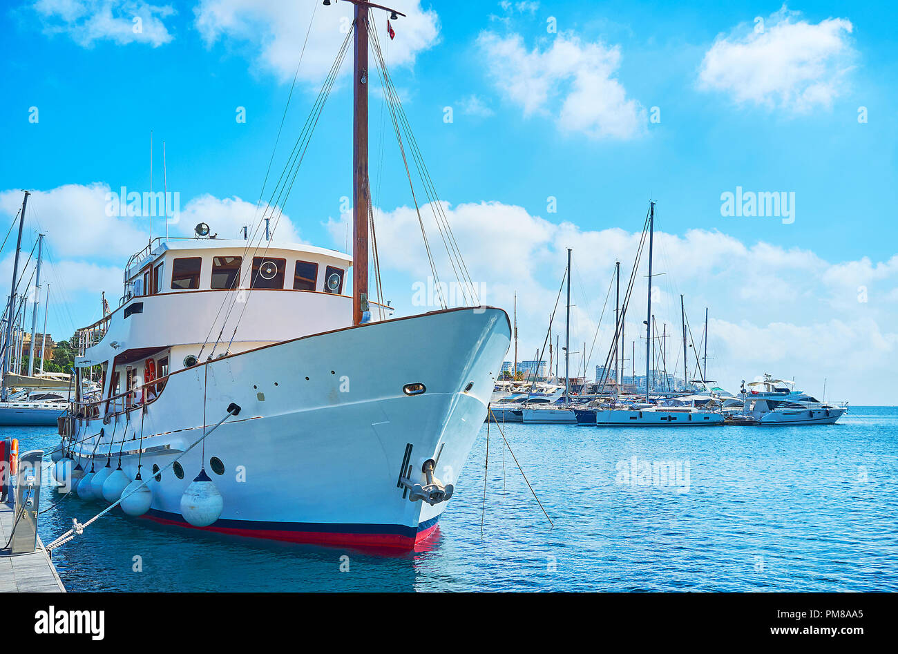 The joyful walk among the sailing yachts and boats in port of Valletta ...