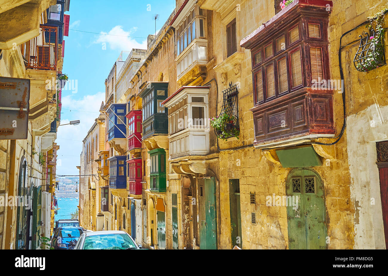 The narrow Archbishop street with densely parked cars, historical ...