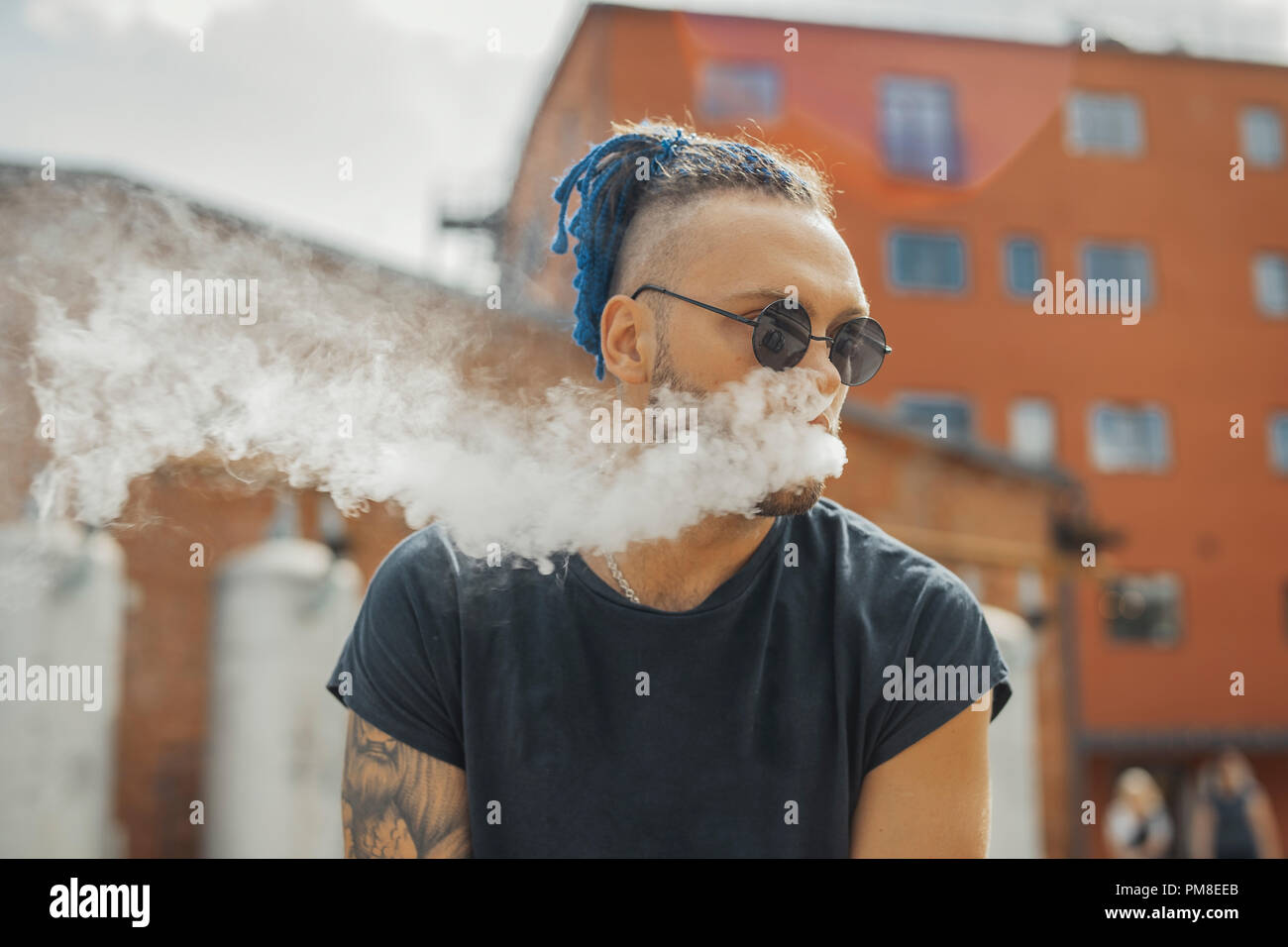 Portrait of young vaping man with dreadlocks. Vapor concept. Vaping e ...