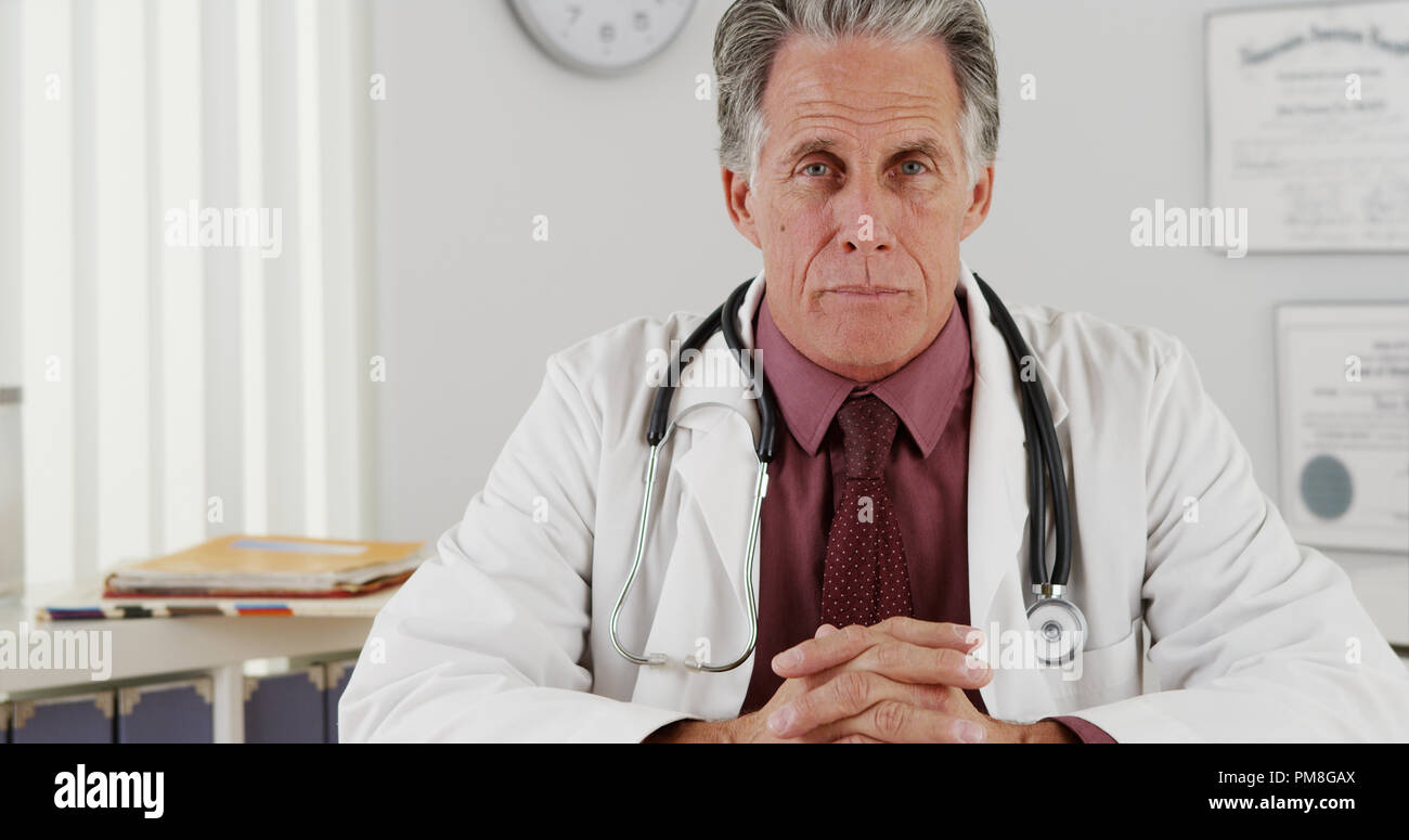 Senior doctor talking to camera Stock Photo - Alamy