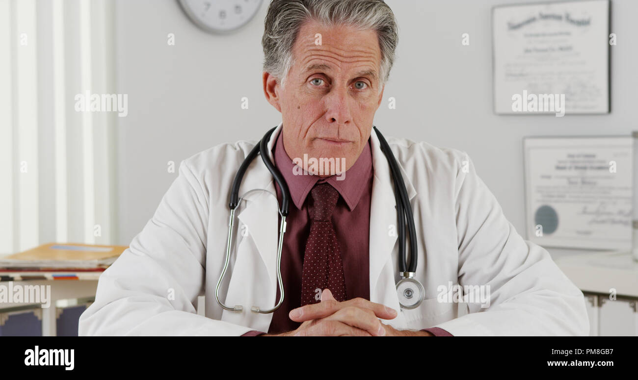 Senior doctor talking to camera Stock Photo - Alamy