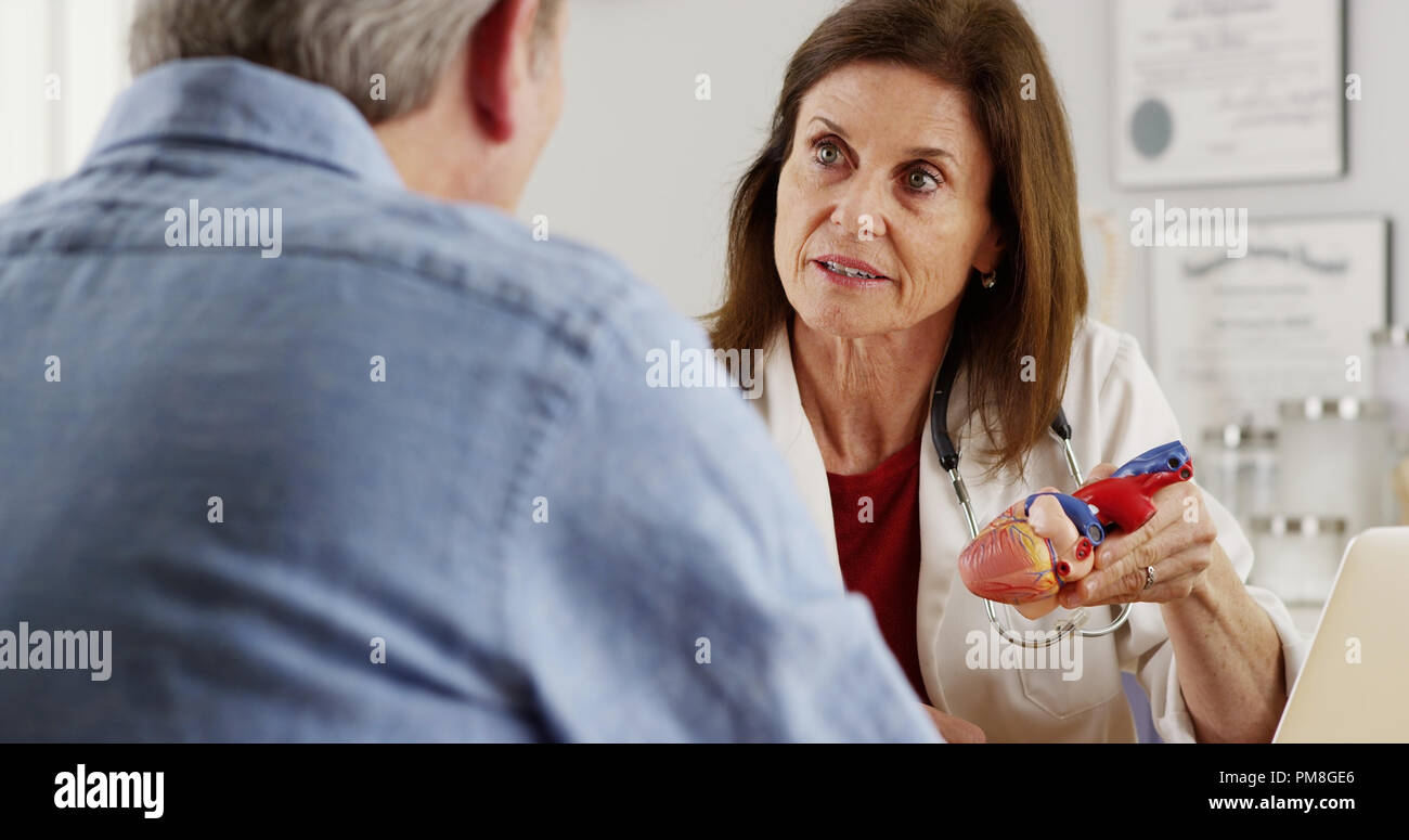 Doctor talking to elderly patient about heart Stock Photo - Alamy