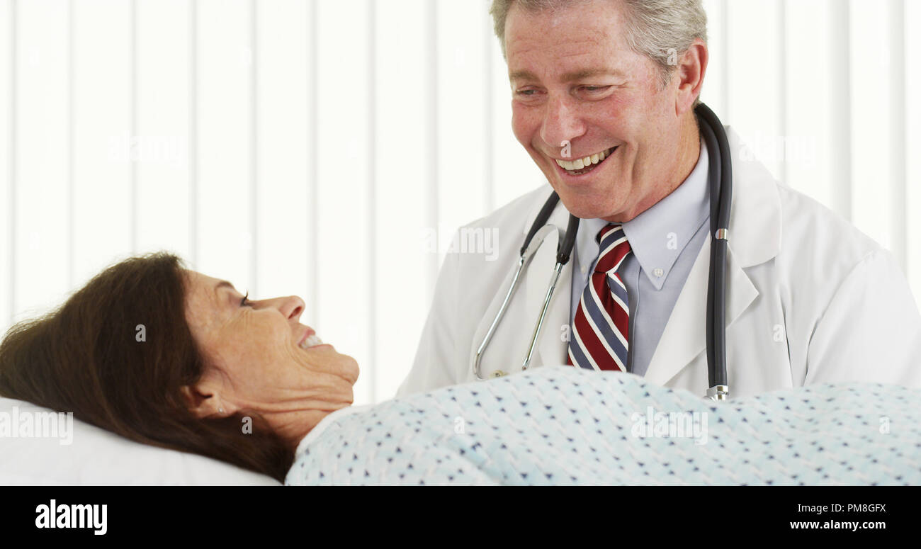 Senior doctor talking and making patient smile Stock Photo - Alamy