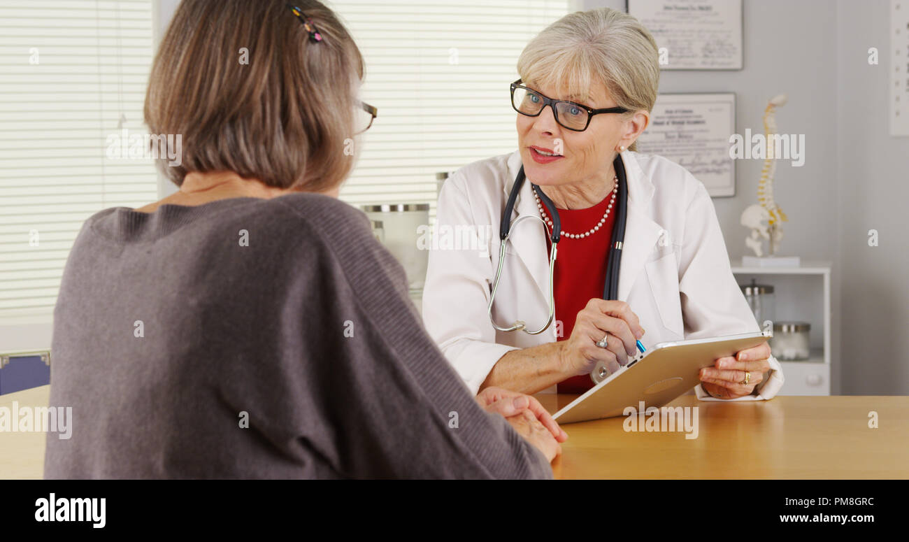 Old female doctor swiping tablet hi-res stock photography and images ...