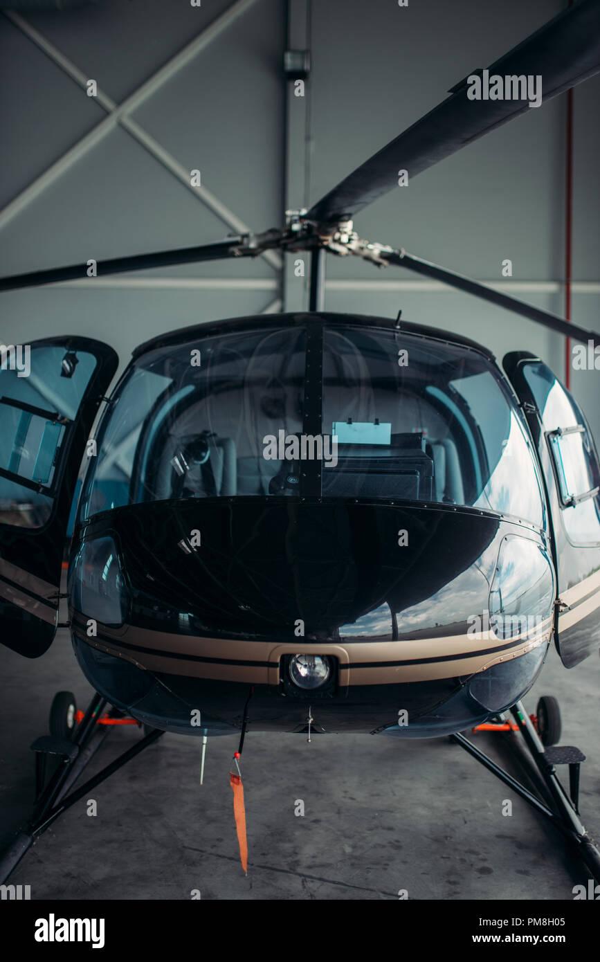 Small helicopter in hangar, nobody. Private airline copter. Chopper ...