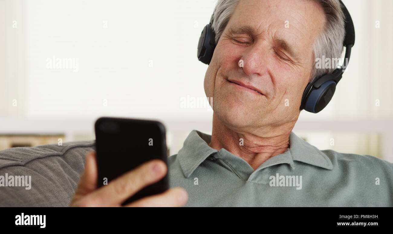 Relaxed middle-aged man listening to music with headphones Stock Photo ...
