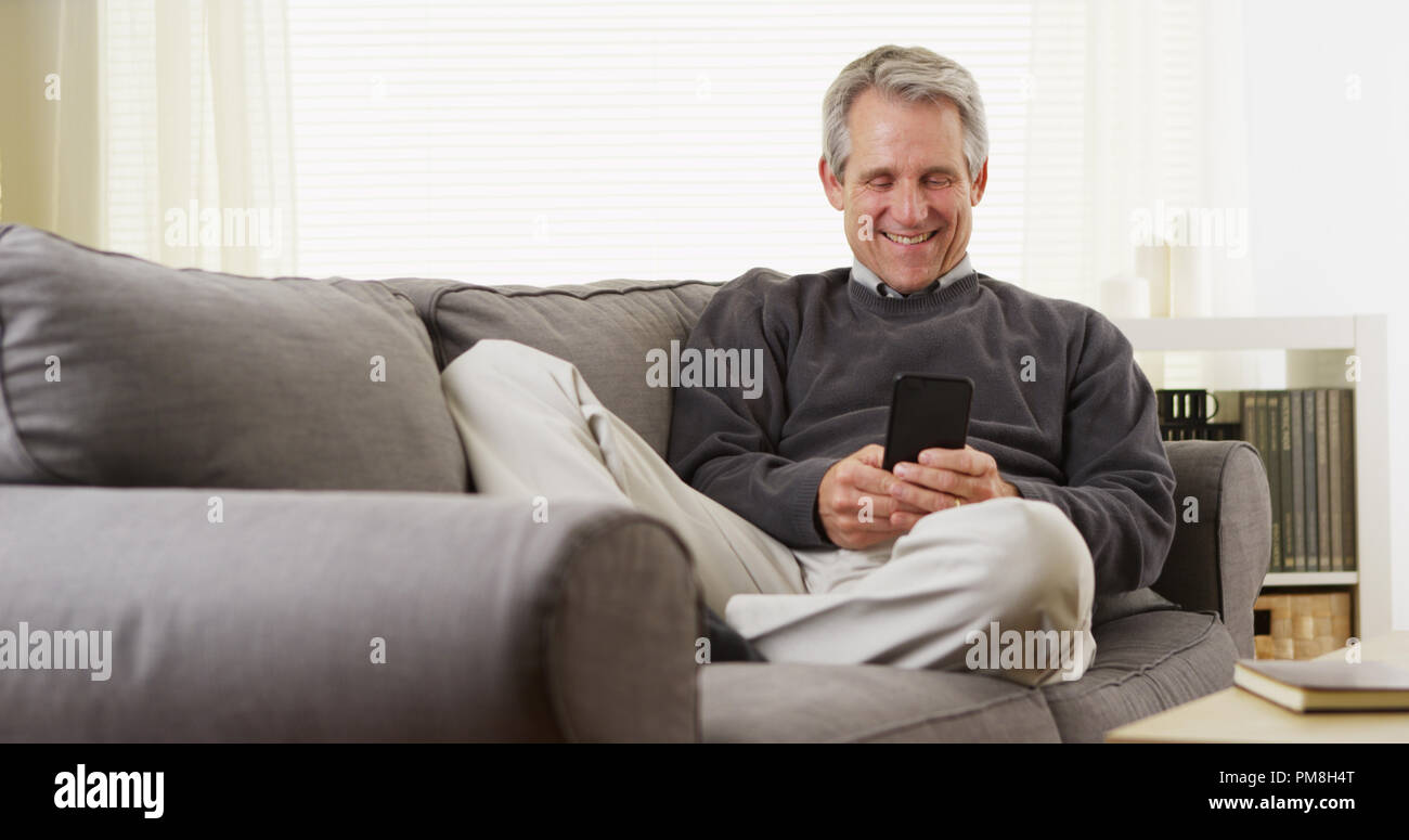 Happy middle-aged white man texting on a cell phone Stock Photo - Alamy
