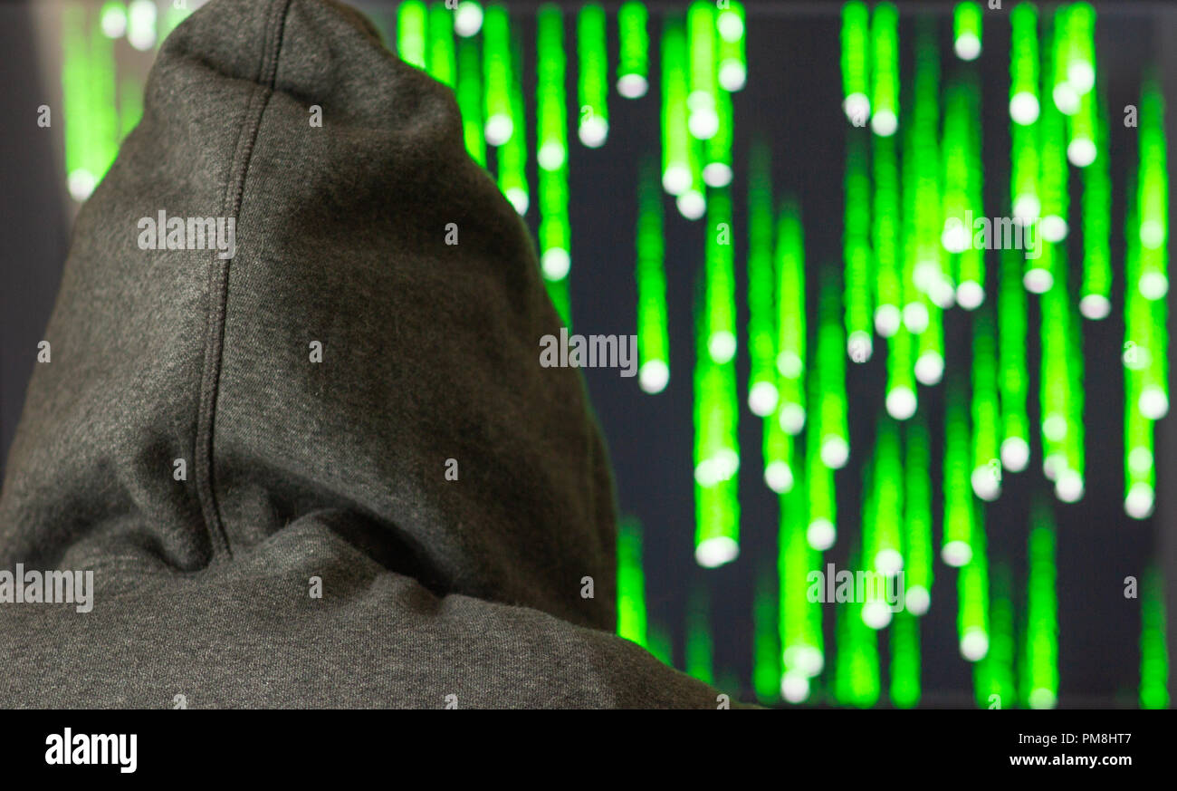 Close-up, hacker in the hood looking at the monitor Stock Photo - Alamy
