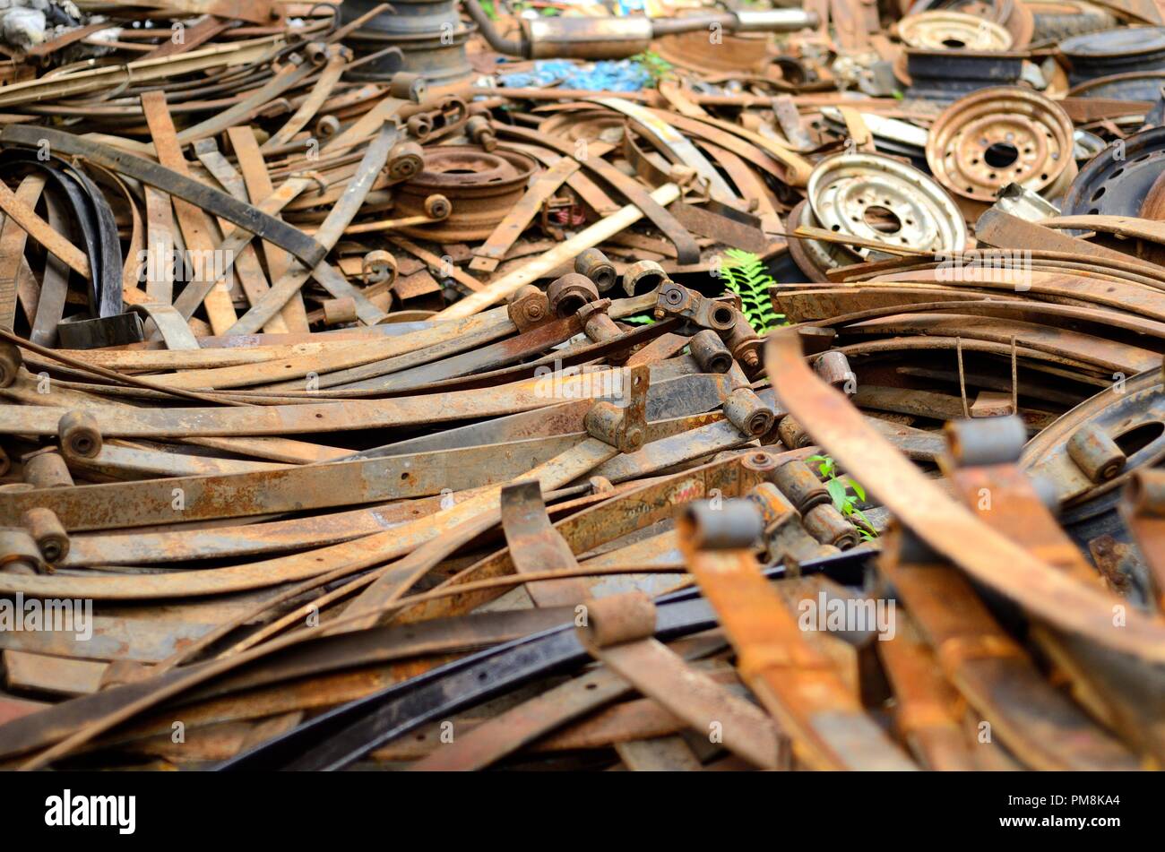 A heap of old rusty metal truck leaf spring in the junkyard, vehicle ...
