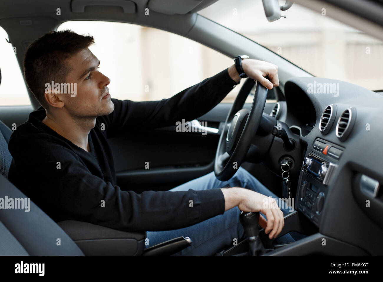 driver of a man in a black T-shirt is sitting in the car Stock Photo ...