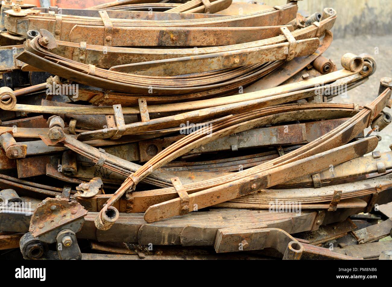 A heap of old rusty metal truck leaf spring in the junkyard, vehicle ...
