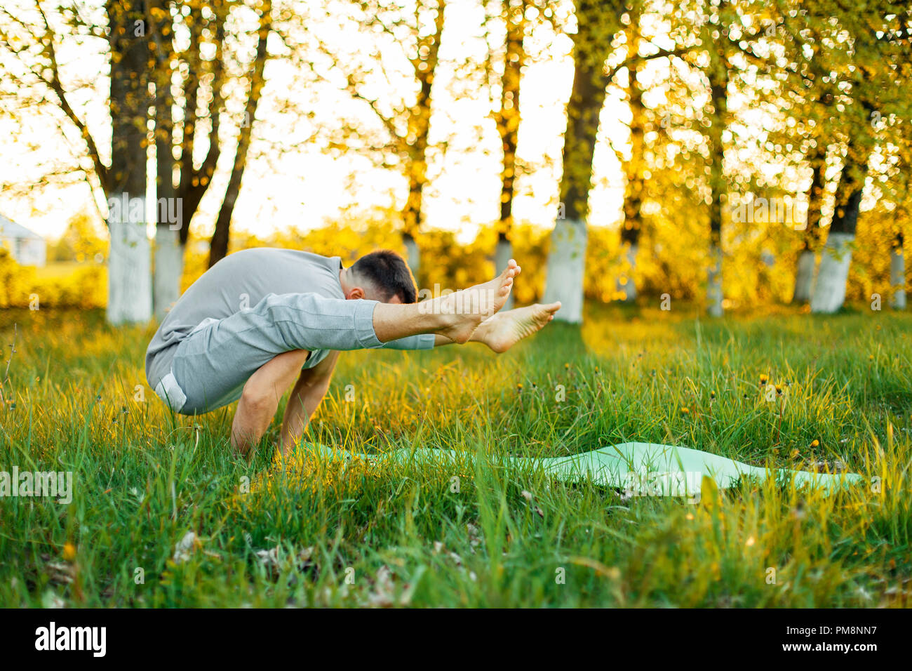 man practicing yoga in the park at sunset. Healthy lifestyle Stock ...