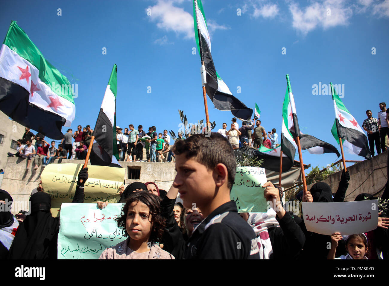 A boy and girl seen next to women holding flags and posters during the ...