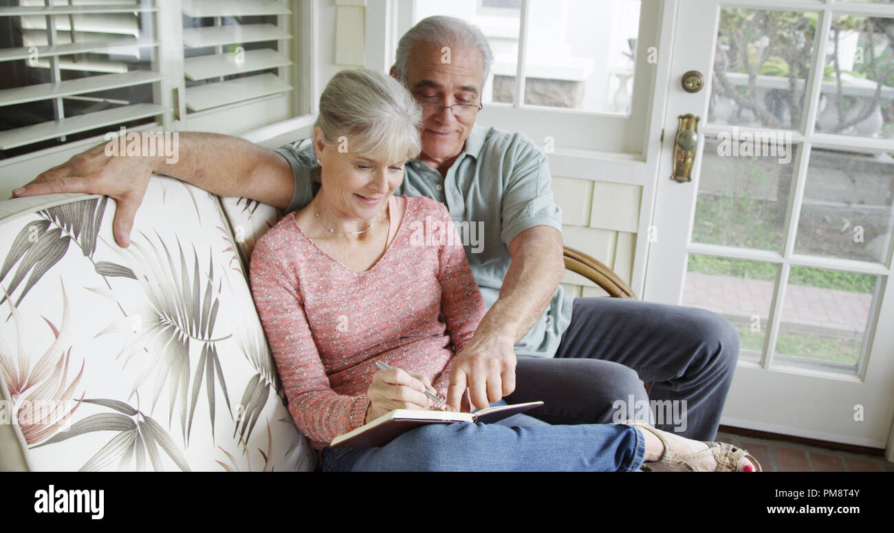 Smiling older couple writing in journal hi-res stock photography and ...