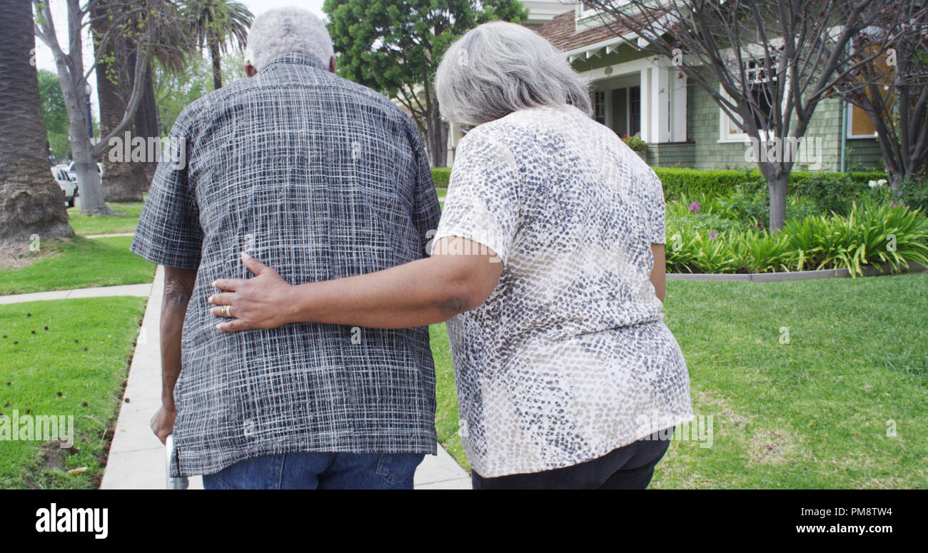 Elderly black woman supporting handicapped husband Stock Photo - Alamy