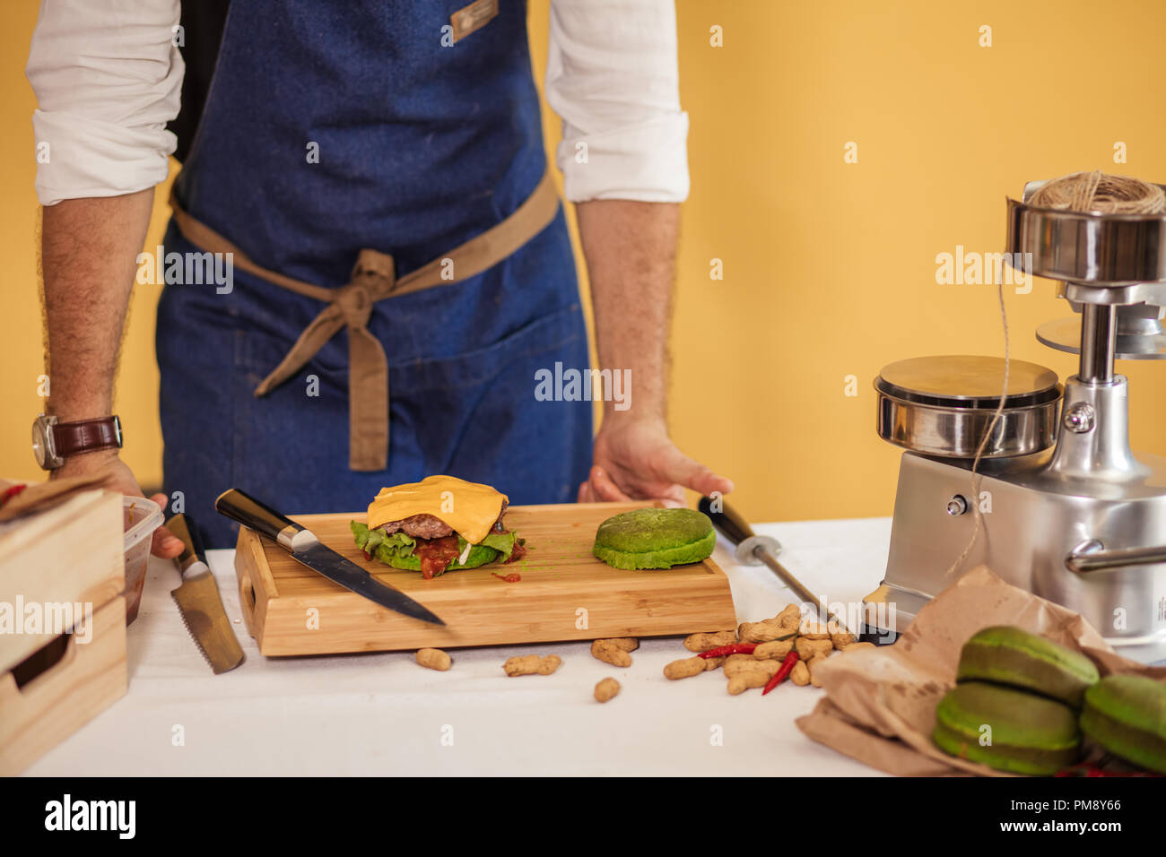 Chef adds basil on burger cooking hamburger concept Stock Photo - Alamy