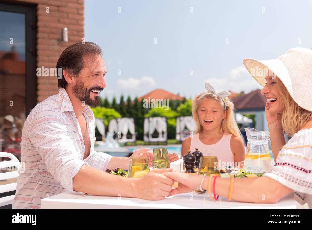 Joyful happy young parents holding hands together Stock Photo - Alamy