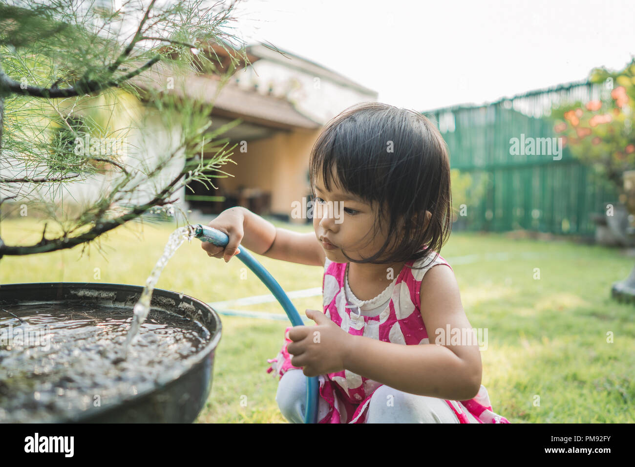 beautiful little child watering the plants Stock Photo - Alamy