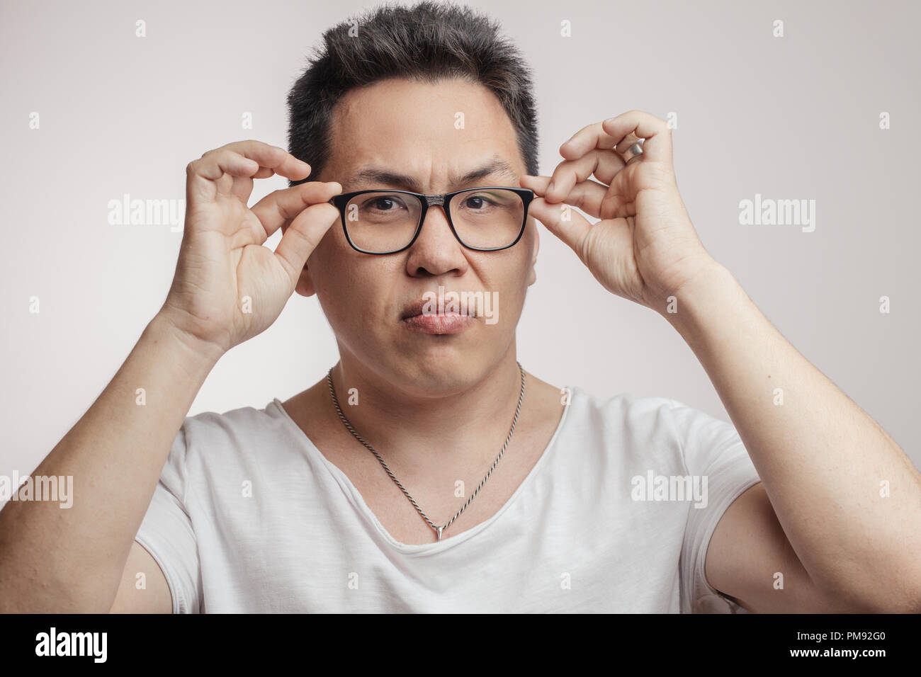 Asian man with suspicion and disbelief on his face, mixed with ...