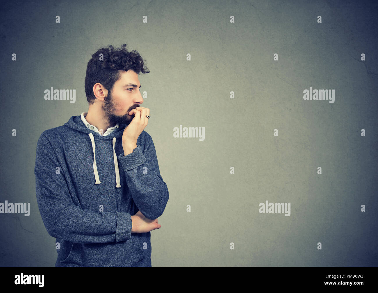 Preoccupied anxious young man biting his fingernails Stock Photo - Alamy