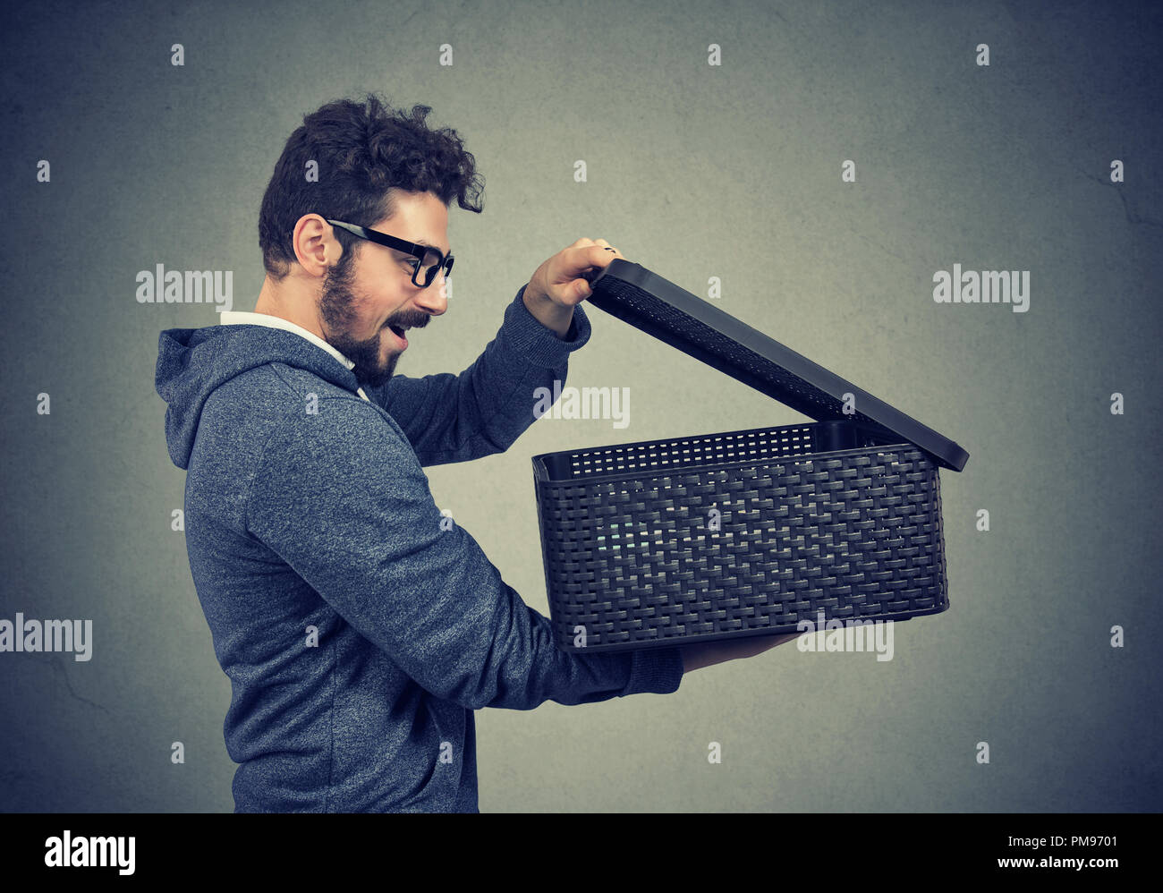 Young man opening a box with something exciting inside it Stock Photo ...
