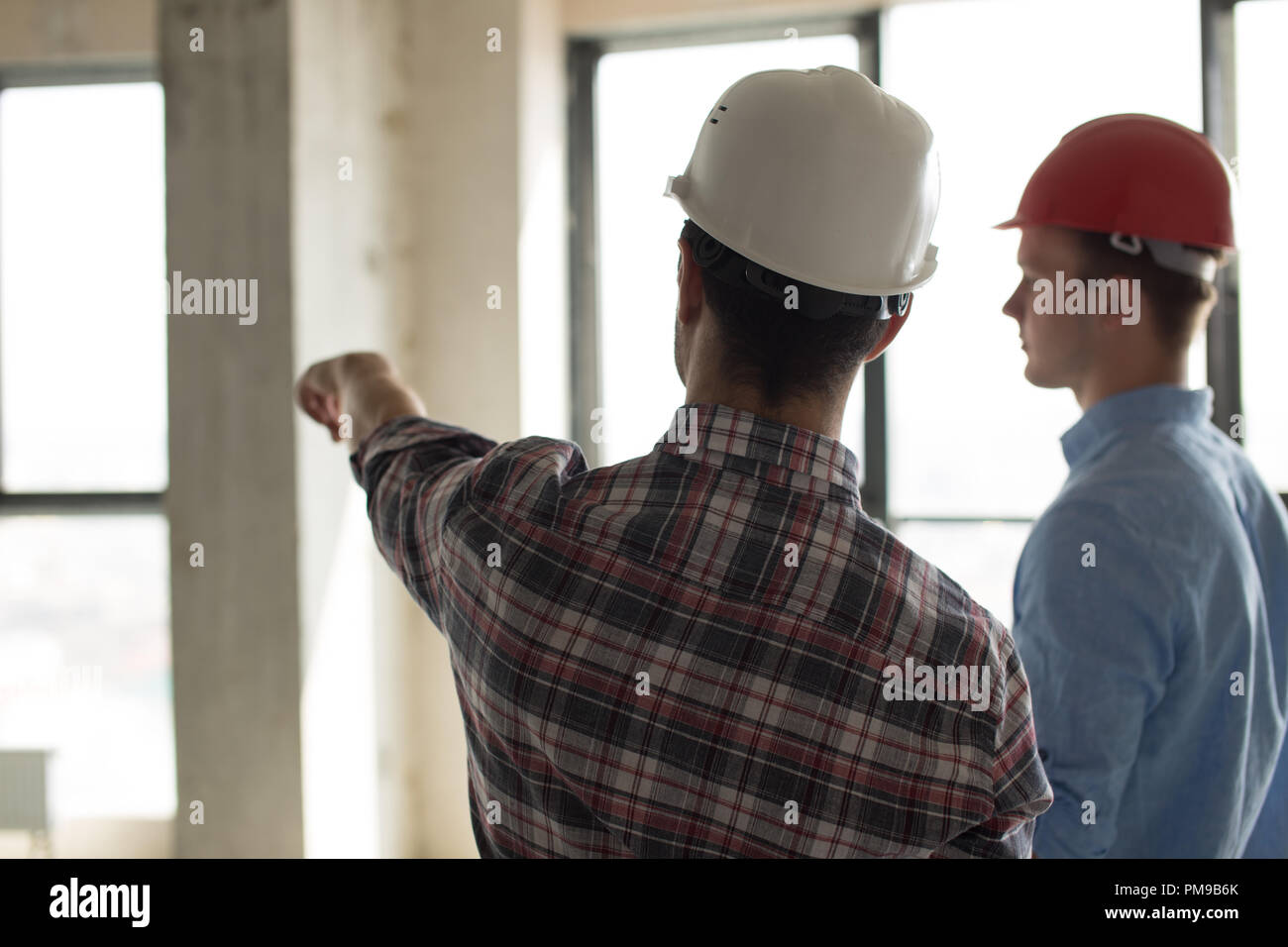 employee wearing helmet showing the place of construction to a ...
