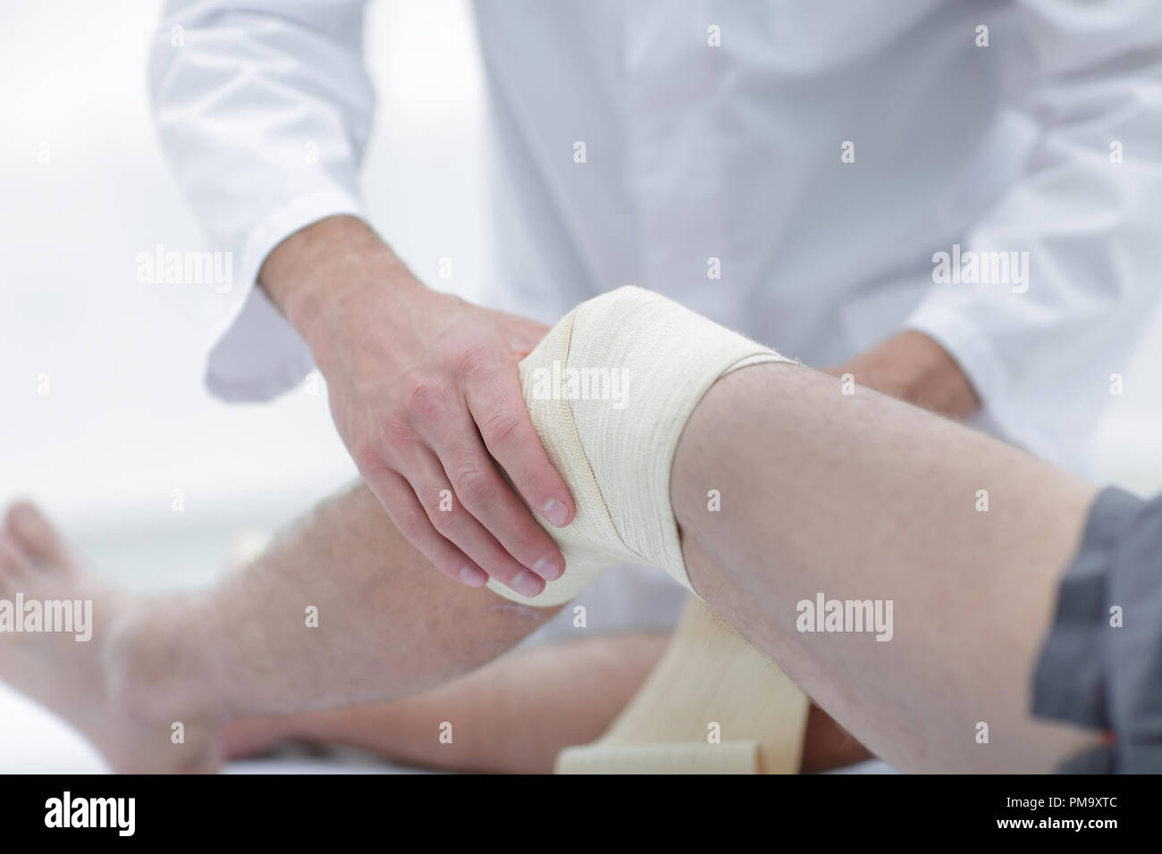 Doctor treats wound on the patient's leg in a clinic room Stock Photo ...
