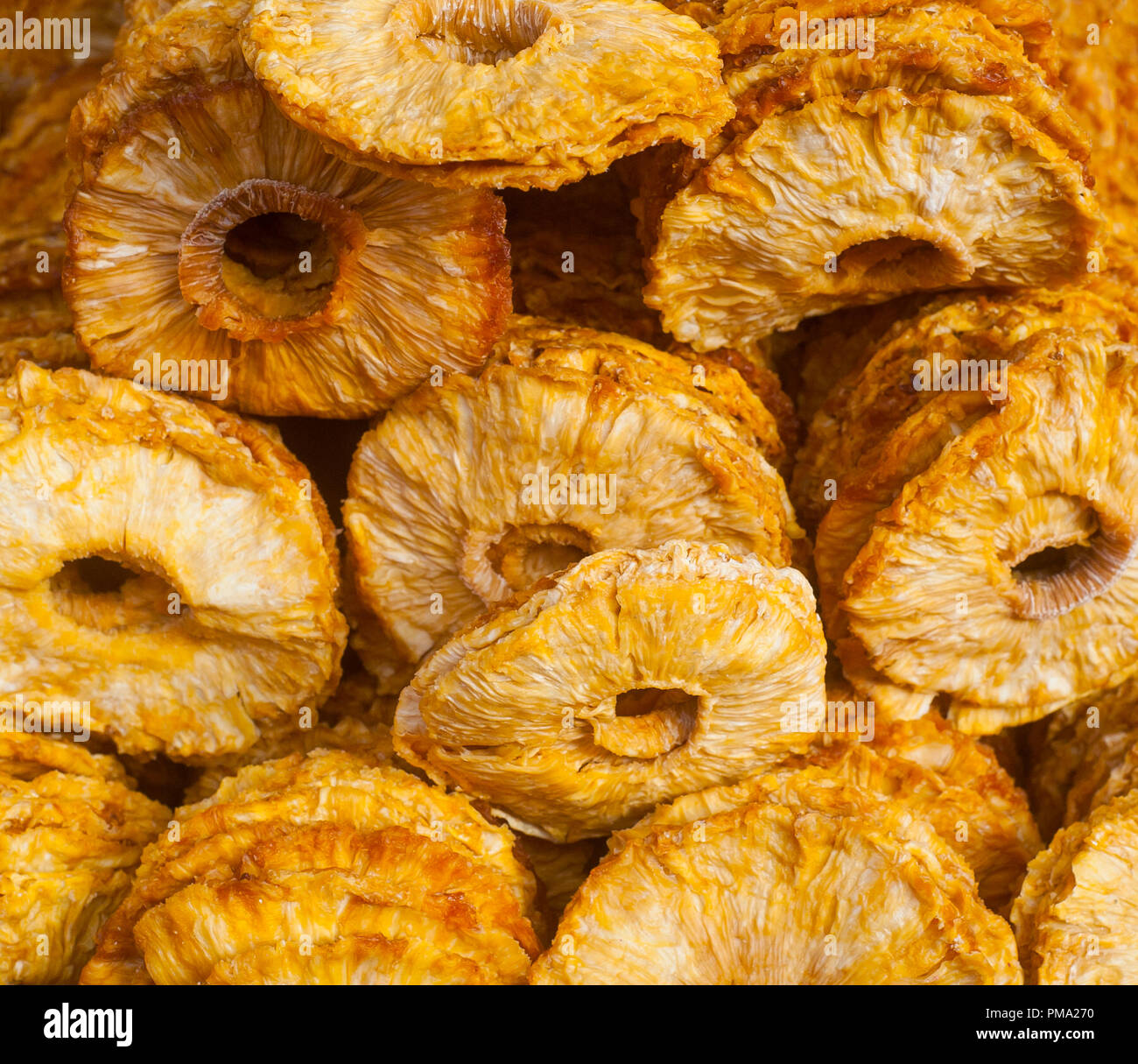dried ananas fruits on a pile on a food market, coloful dried fruits ...