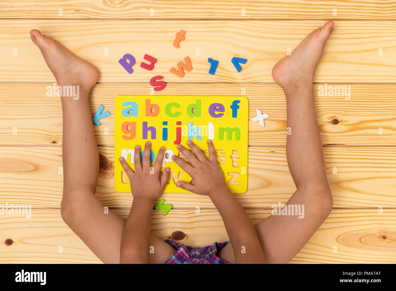 Preschool student learning the alphabet letters playing on the floor at ...