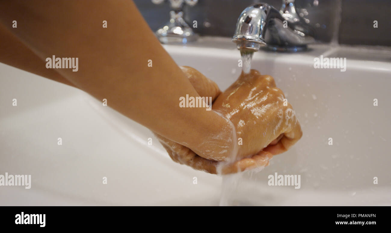 Young pretty black woman washing her hands Stock Photo - Alamy