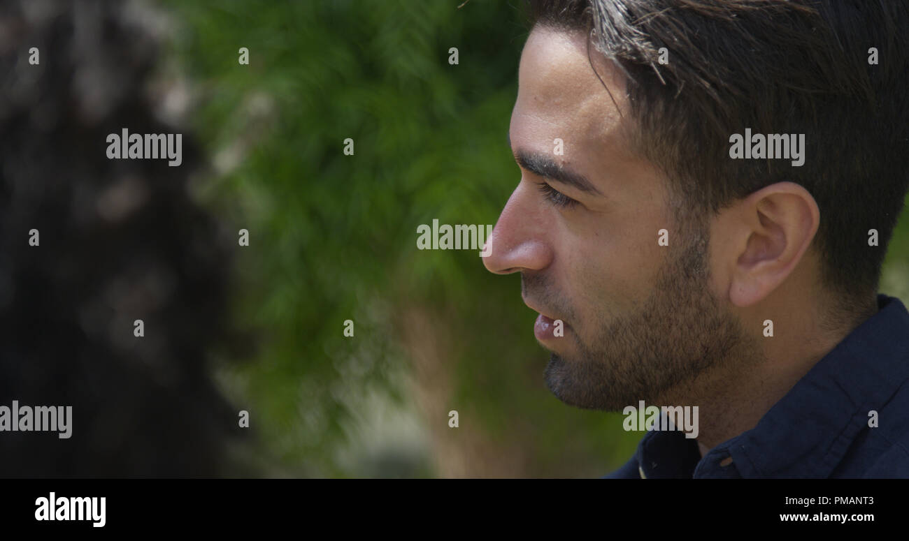 Profile of hispanic man in the park Stock Photo - Alamy