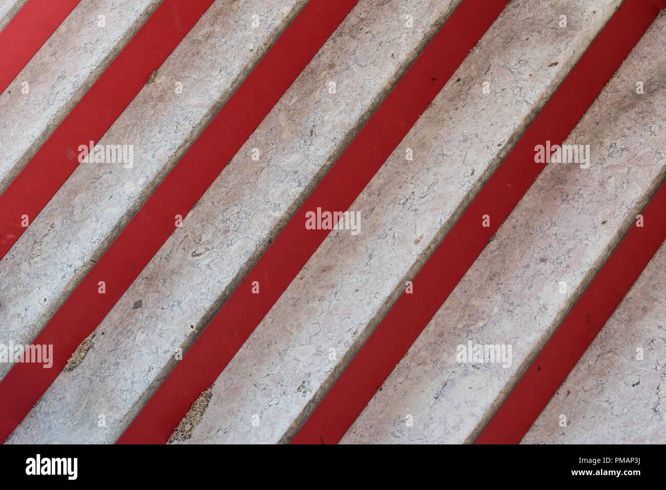 Staircase with marble and red painted steps forming angled parallel ...
