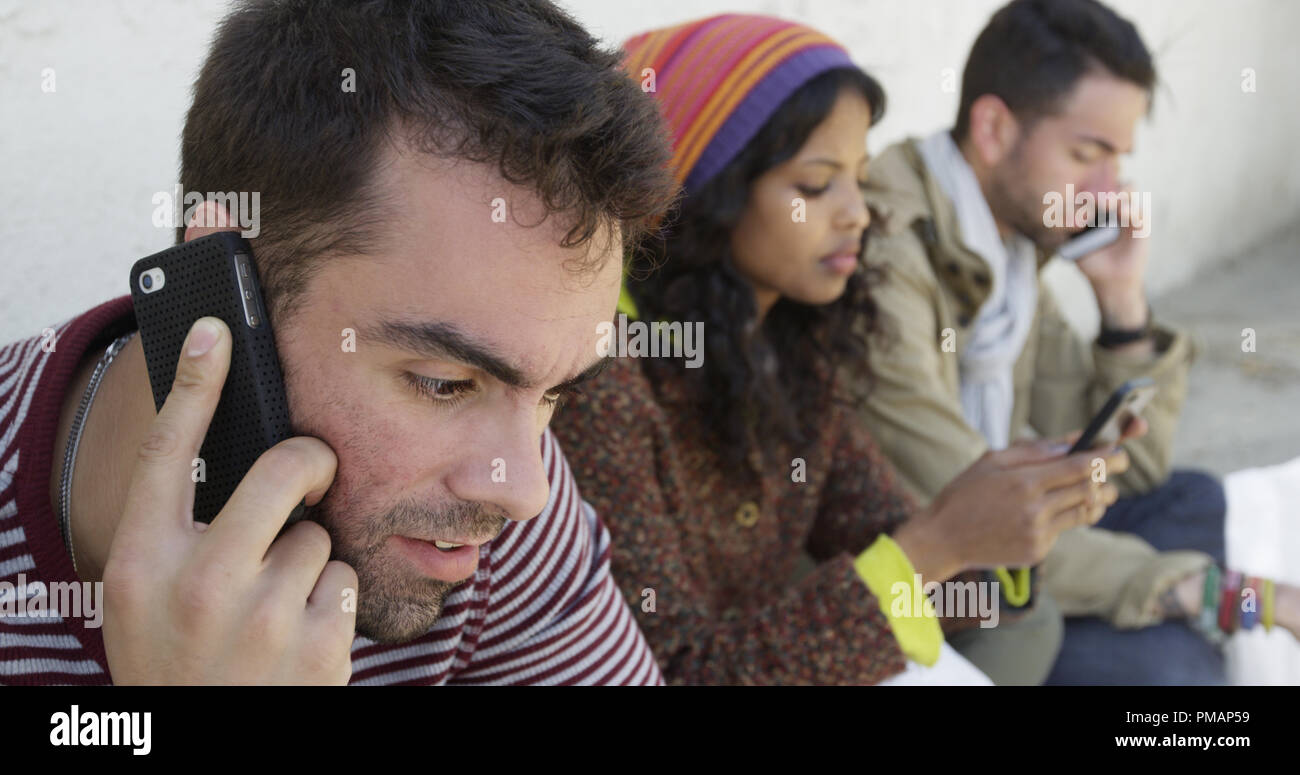 Attractive Group of multiracial friends talking and texting on their ...