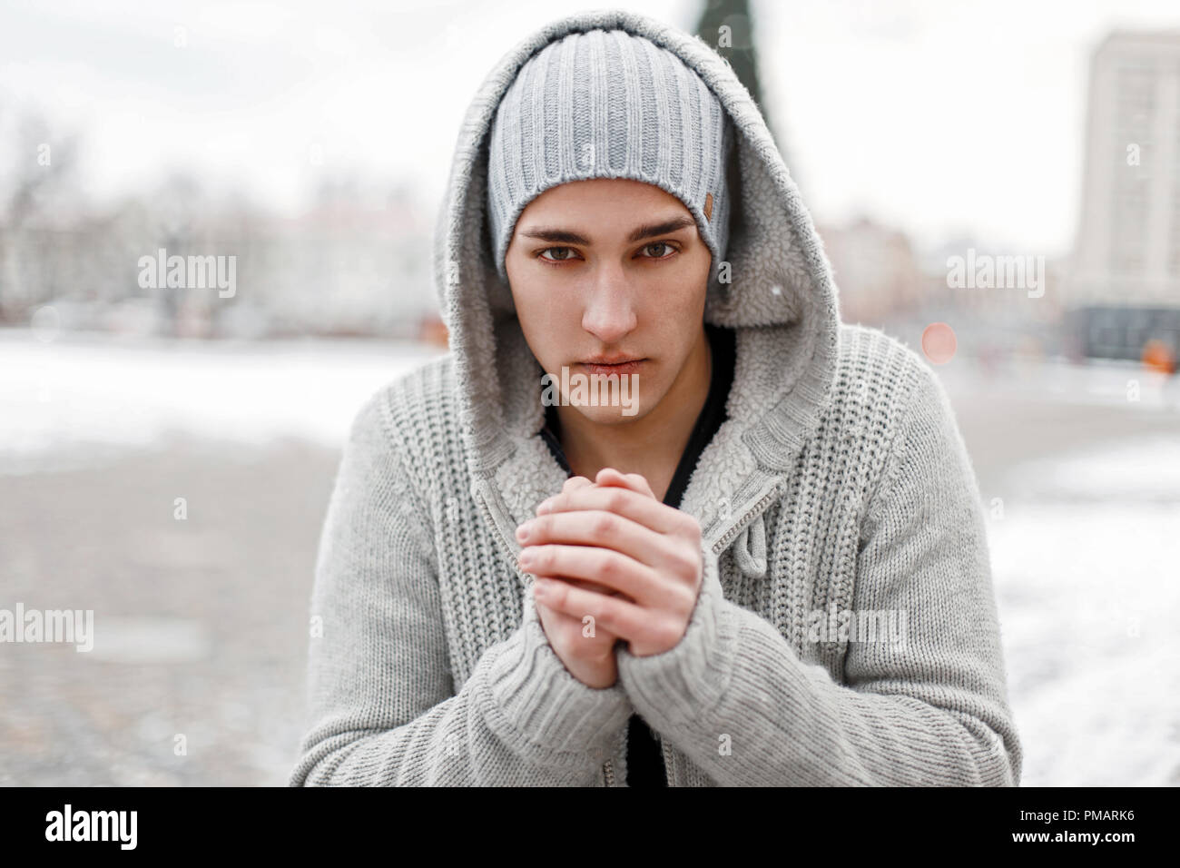 Handsome young man in knitted clothes in a cold winter day Stock Photo ...