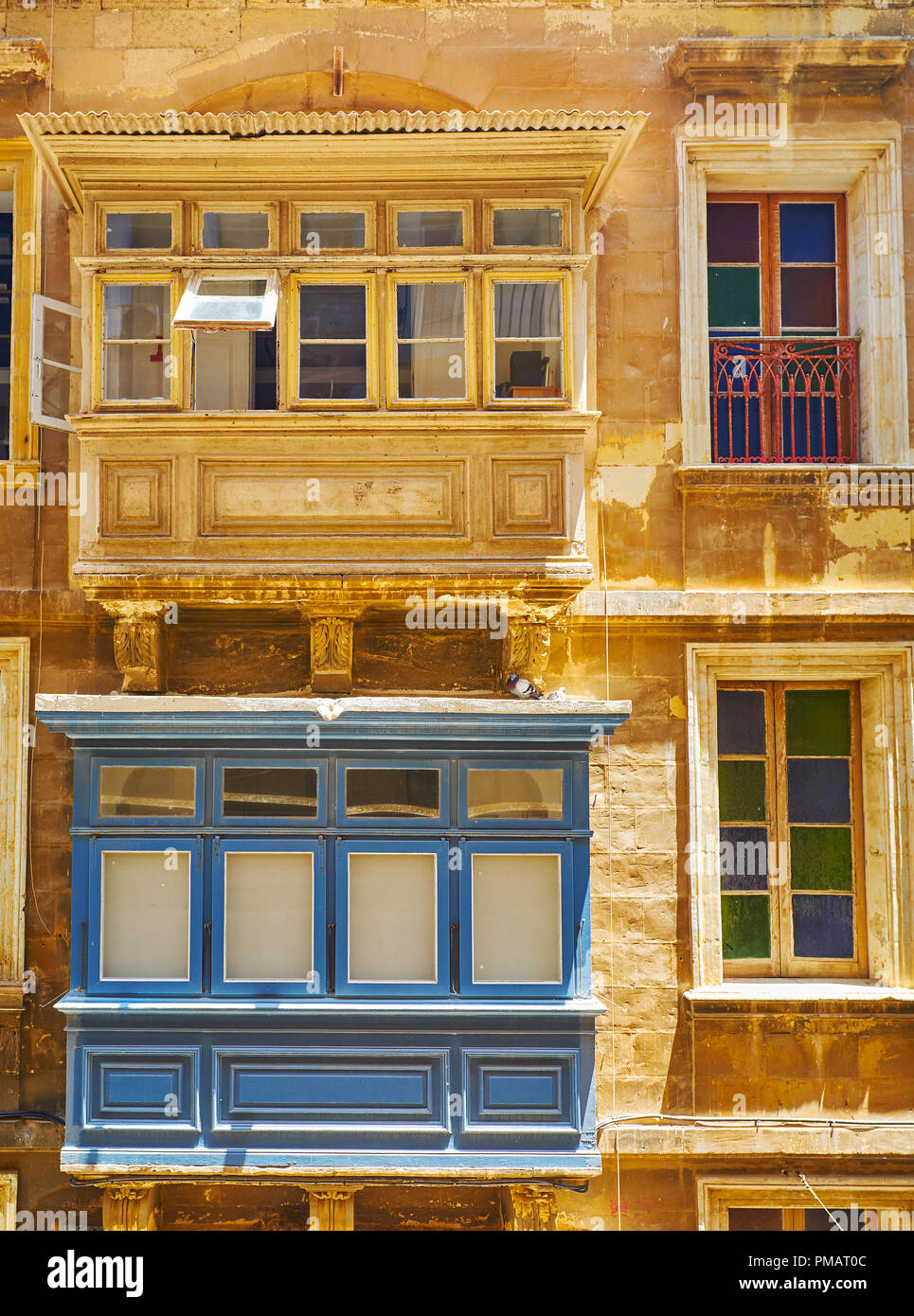 The stained-glass windows and colored wooden Maltese balconies of the ...