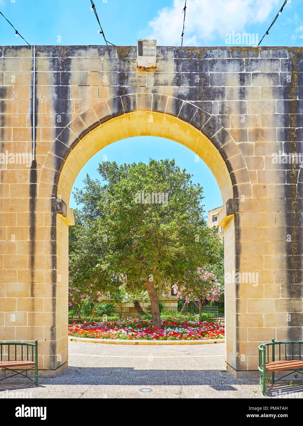 The lush greenery and flower beds of Lower Barrakka Gardens through the ...