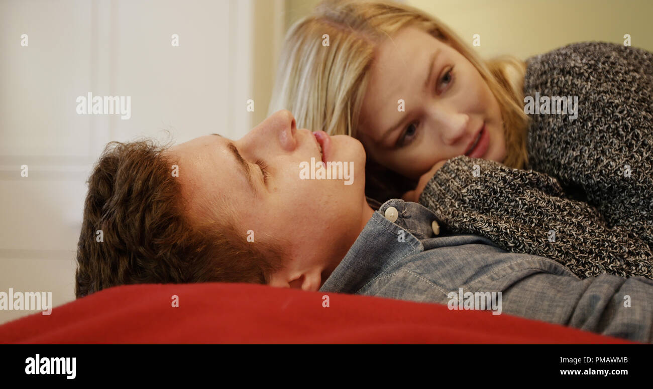 Sweet young couple cuddling in bed Stock Photo - Alamy