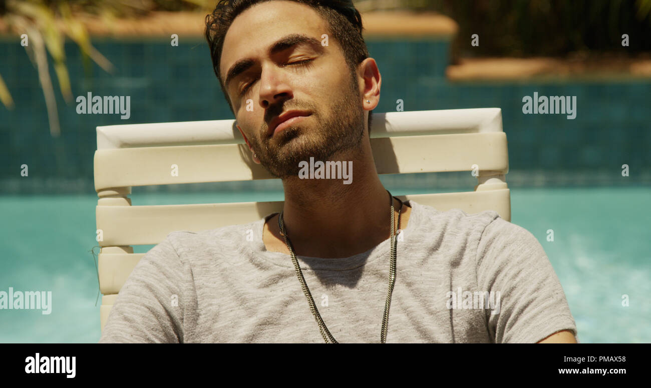 Mexican man sunbathing by the pool Stock Photo - Alamy