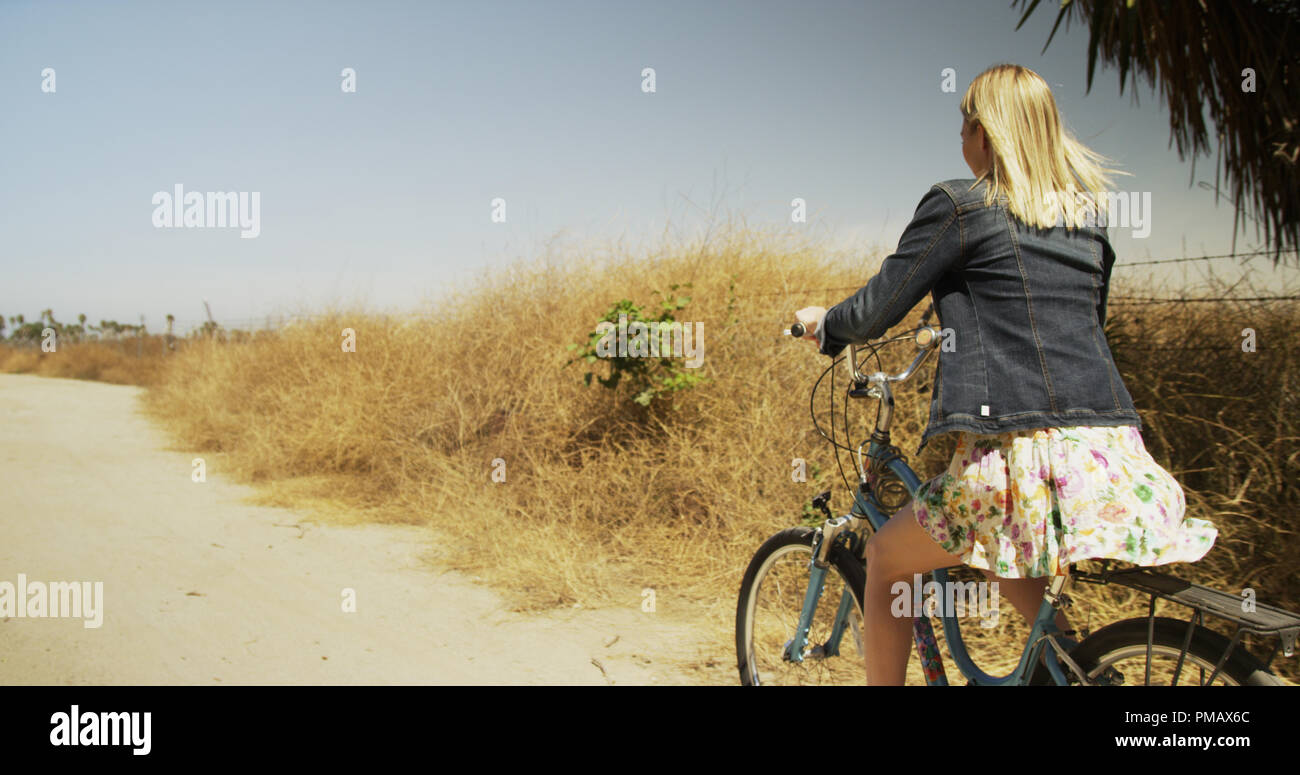 Pretty young white woman on bike riding dirt road Stock Photo - Alamy