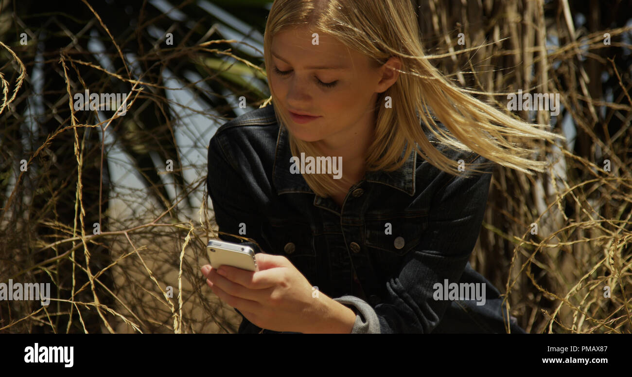 Young attractive white woman texting in nature Stock Photo - Alamy