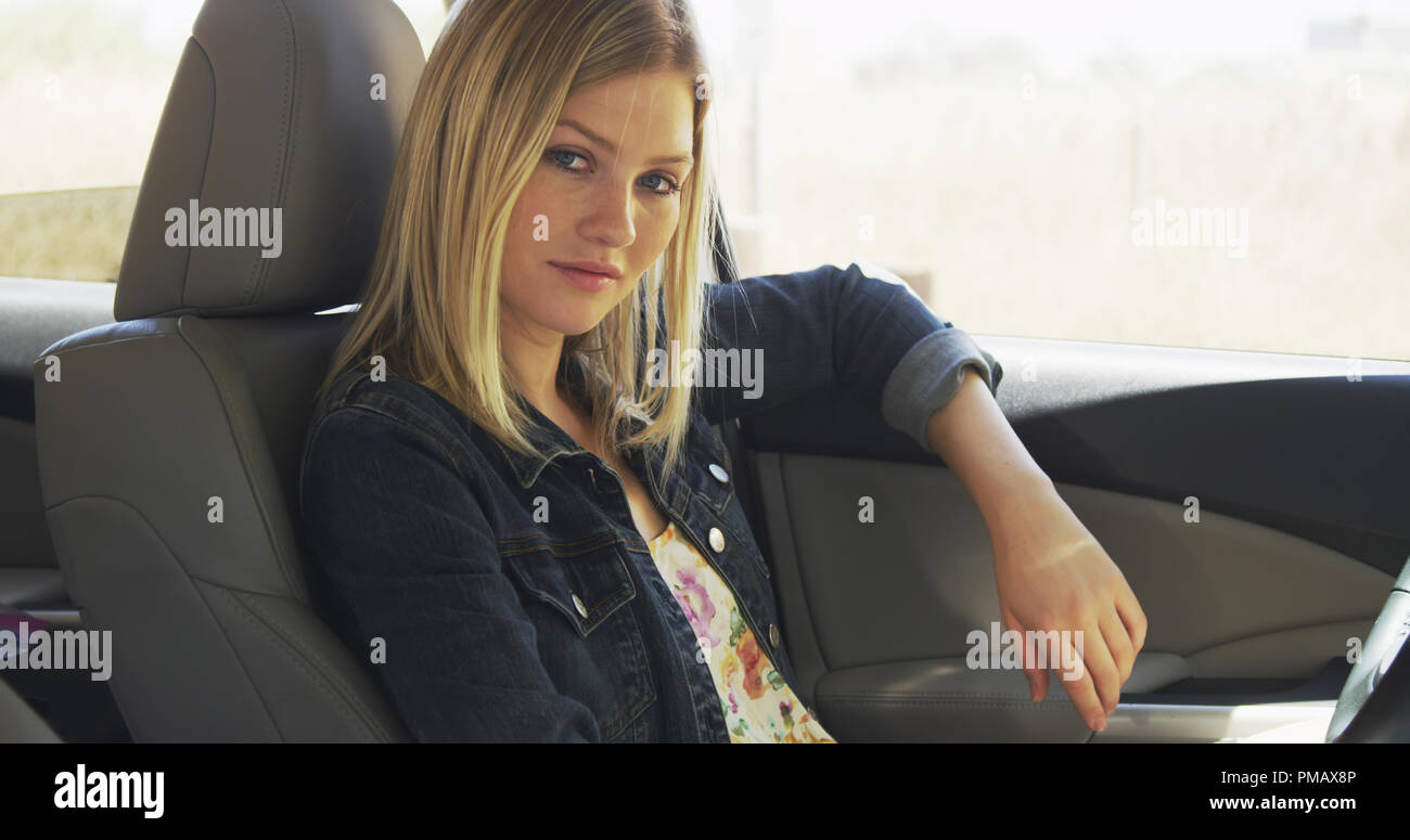 Young attractive white woman sitting inside car Stock Photo - Alamy